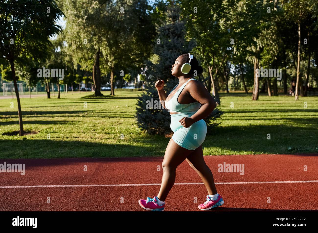 An African American woman in sportswear, celebrating her curves, runs ...