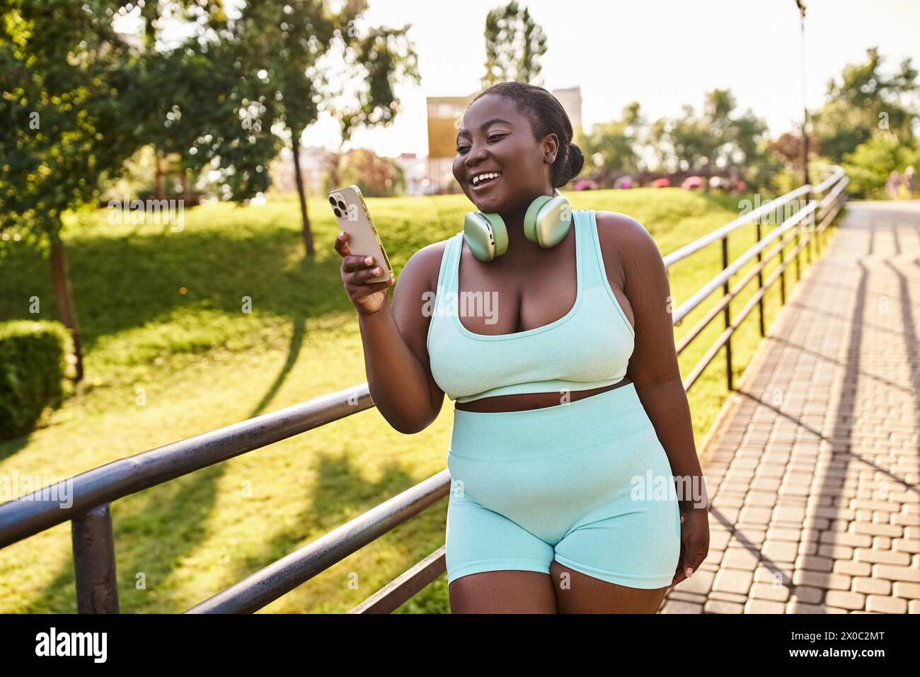 A stylish African American woman in a blue outfit is engrossed in her ...