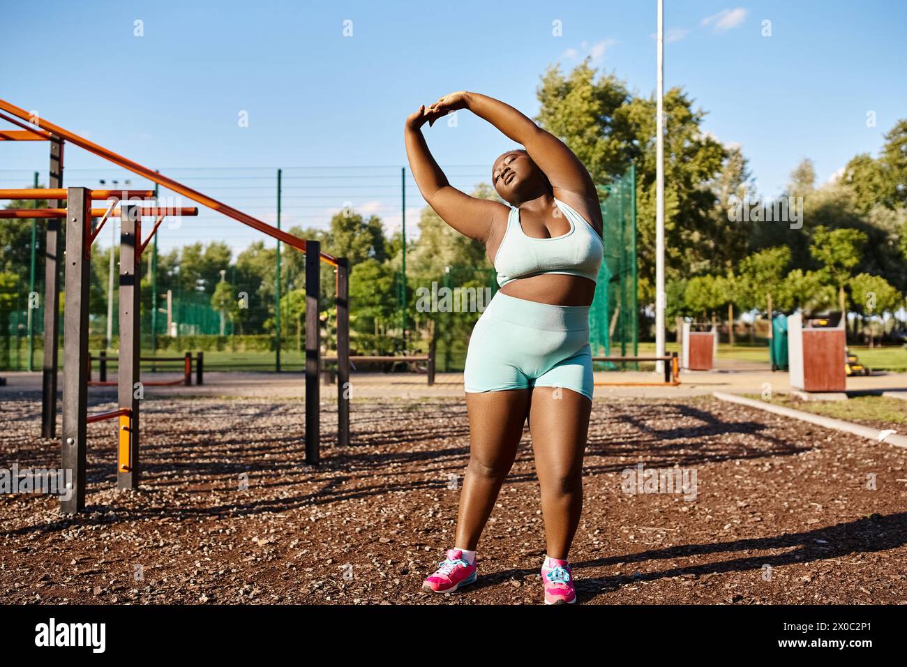 An African American woman in blue sports bra and shorts stands ...