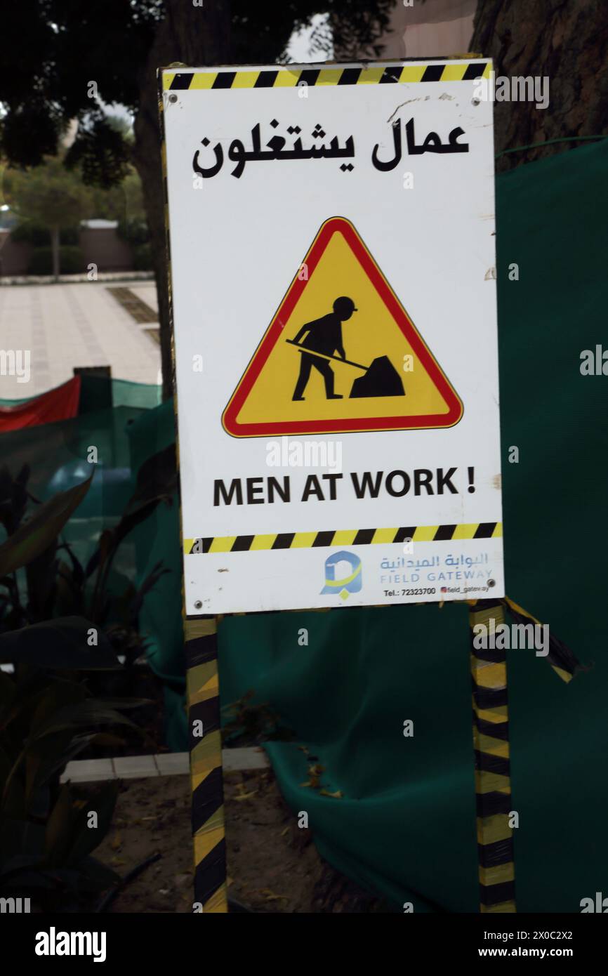 Bilingual Construction Sign "Men at Work Muscat Oman Stock Photo - Alamy