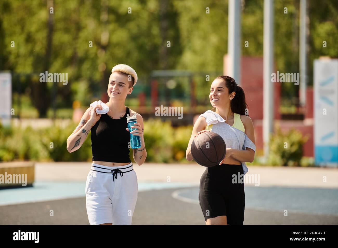 Two athletic young women stand confidently on a basketball court on a ...