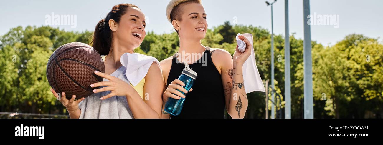Two young women, friends, stand together on the basketball court, ready ...