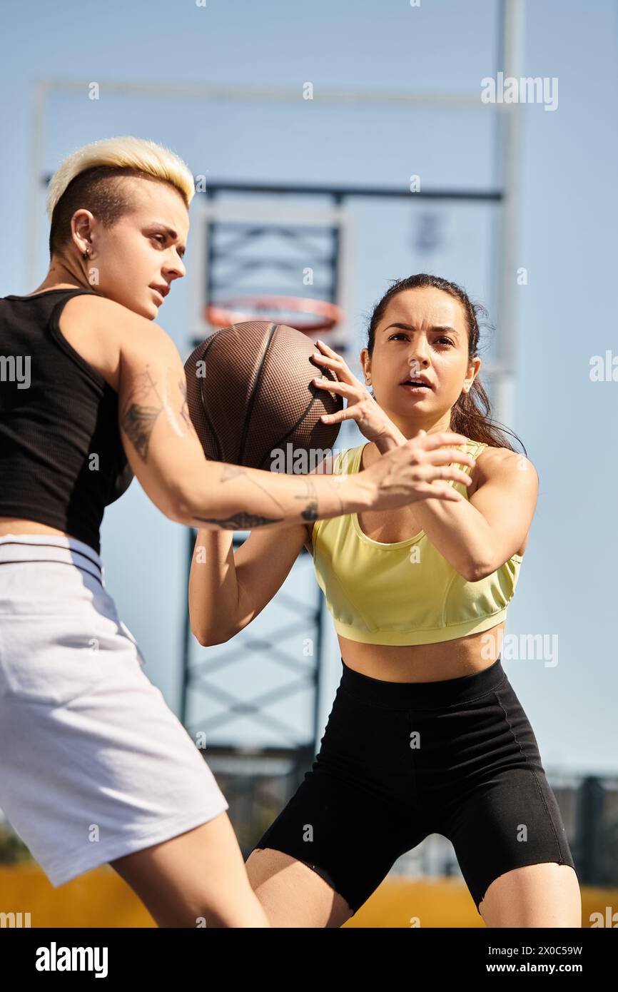 women playing basketball together outdoors on a sunny day, showcasing ...