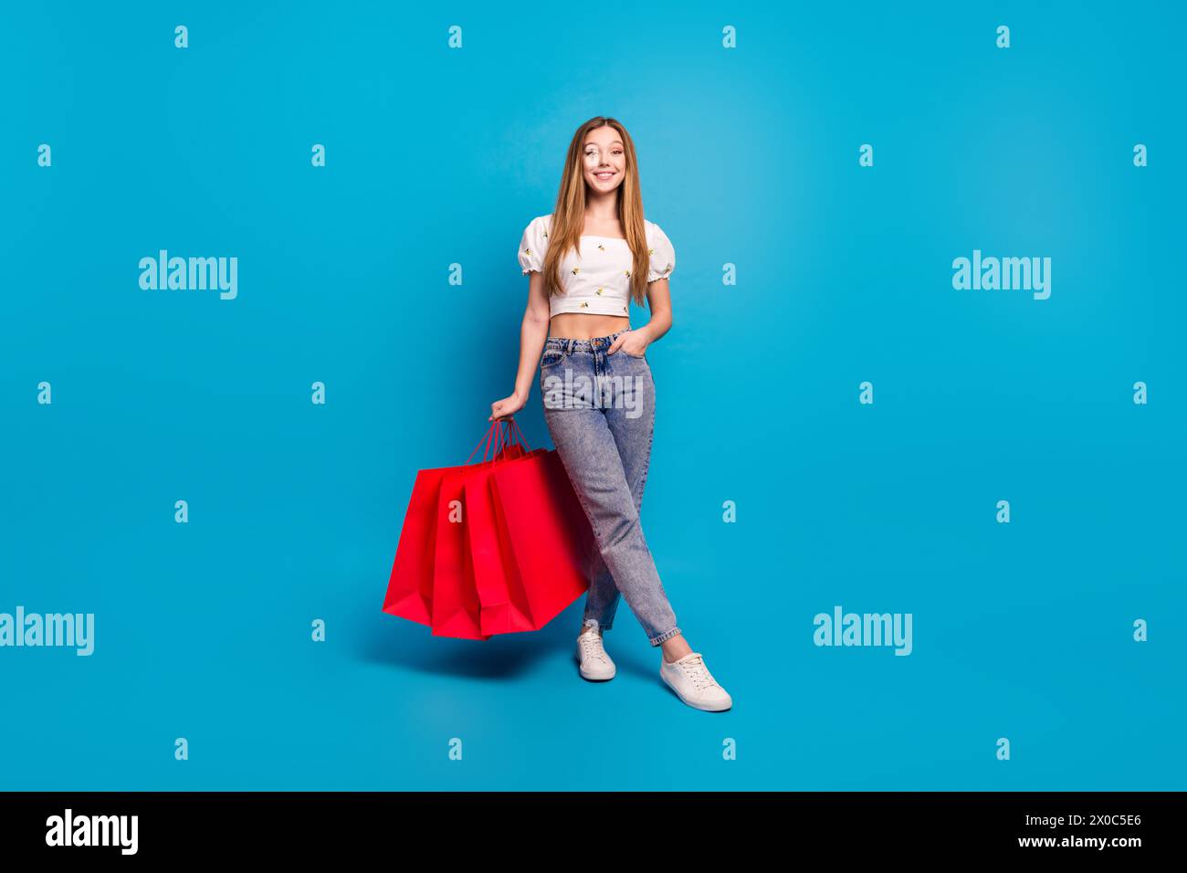 Full length portrait of lovely girl hold mall bags empty space wear top ...