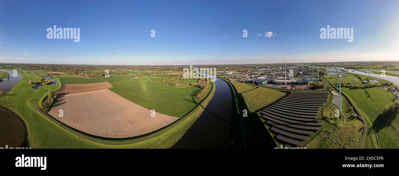 Dutch landscape panorama of wind turbine and solar panels with waterway ...