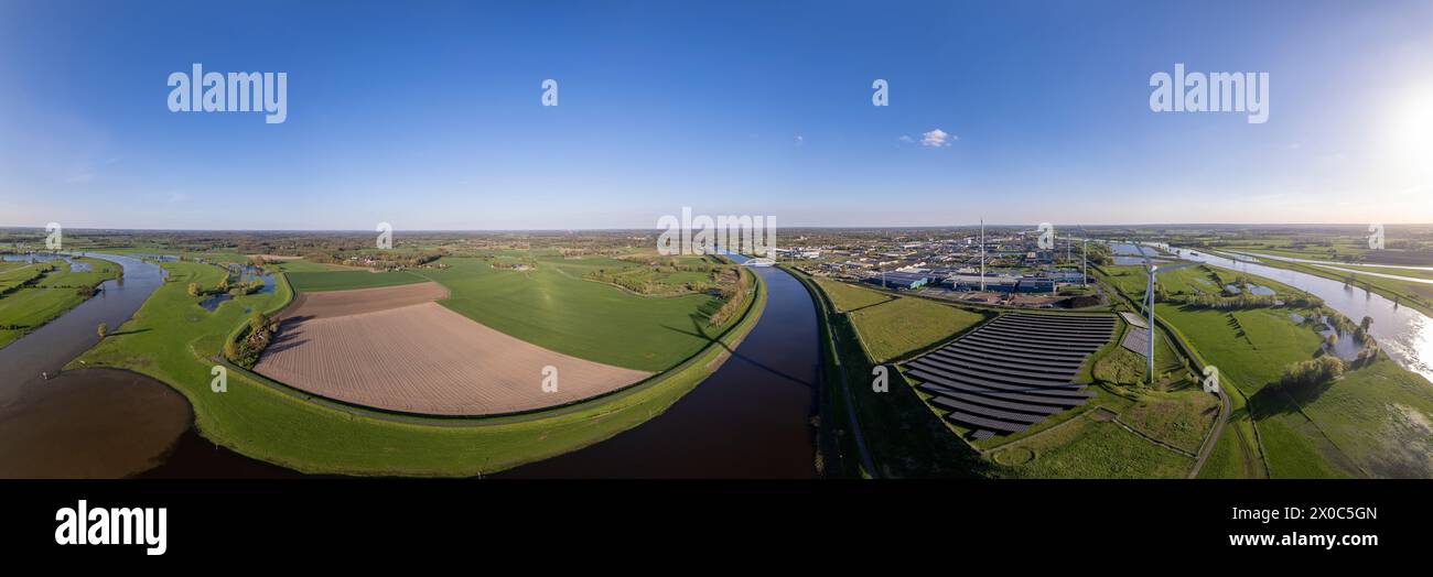 Dutch landscape panorama of wind turbine and solar panels with waterway ...