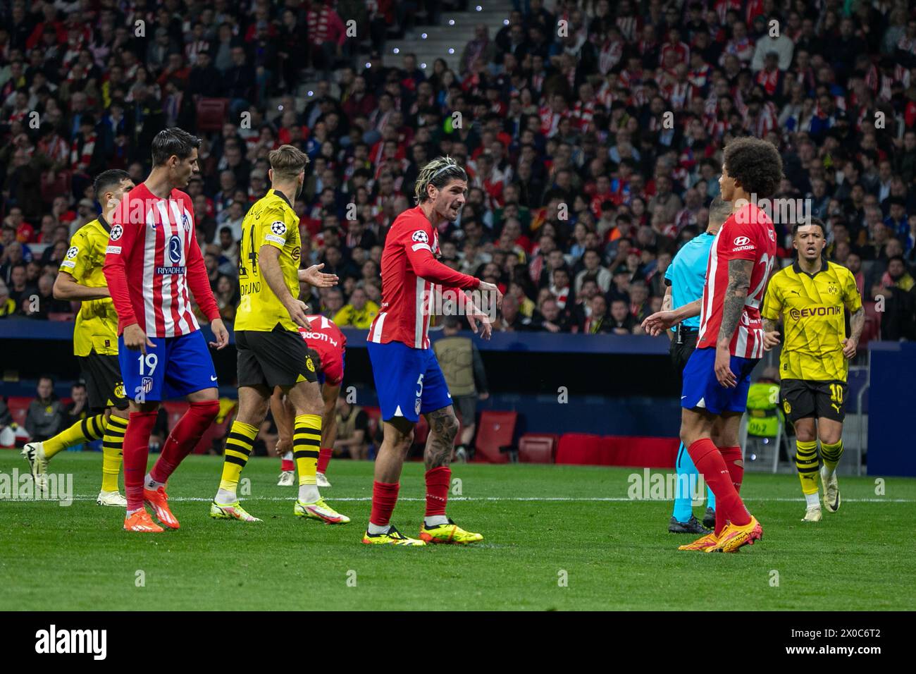 Atletico de Madrid player Rodrigo de Paul (C) stretches his arm to ...