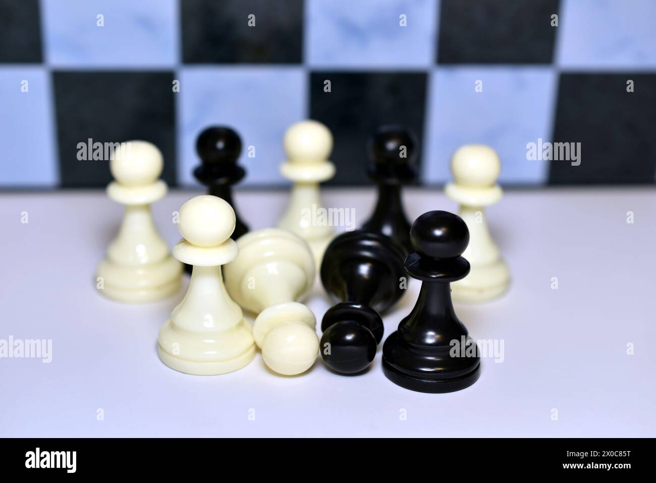 In the picture, chess pieces of pawns of two colors stand and lie mixed ...