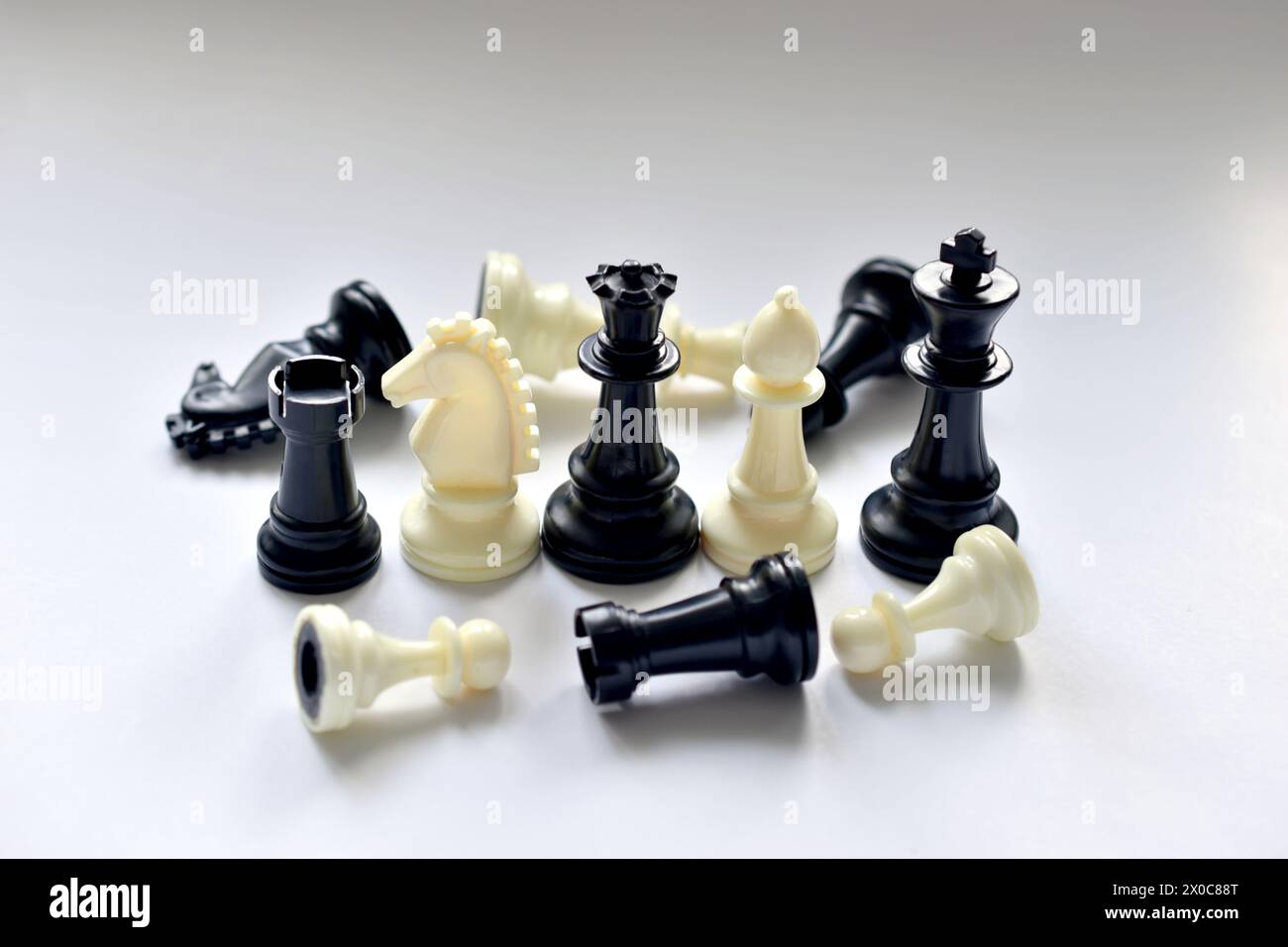 In the picture, chess pieces of two colors are standing and lying mixed ...