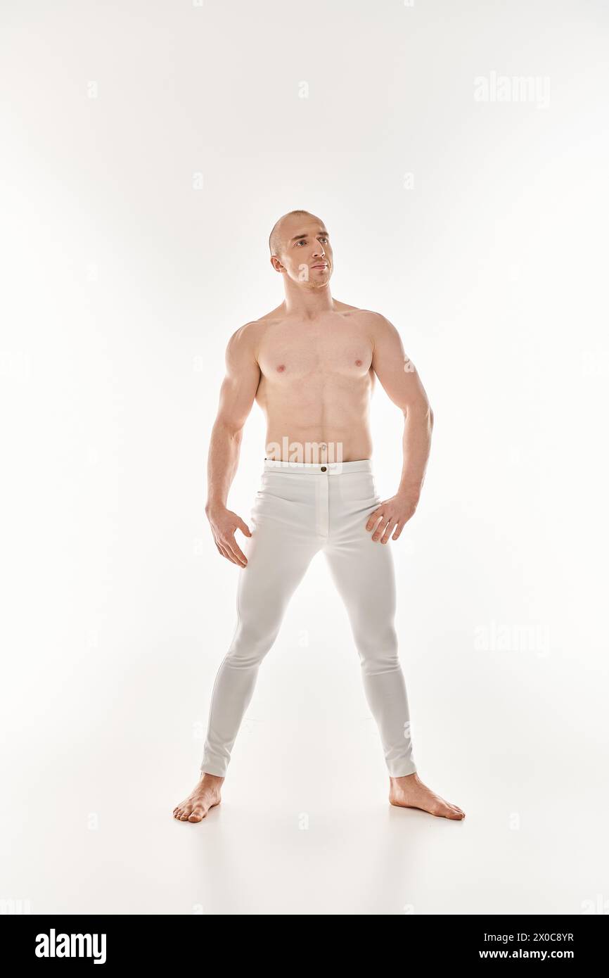 A young man in white pants strikes a dynamic pose, showcasing acrobatic ...