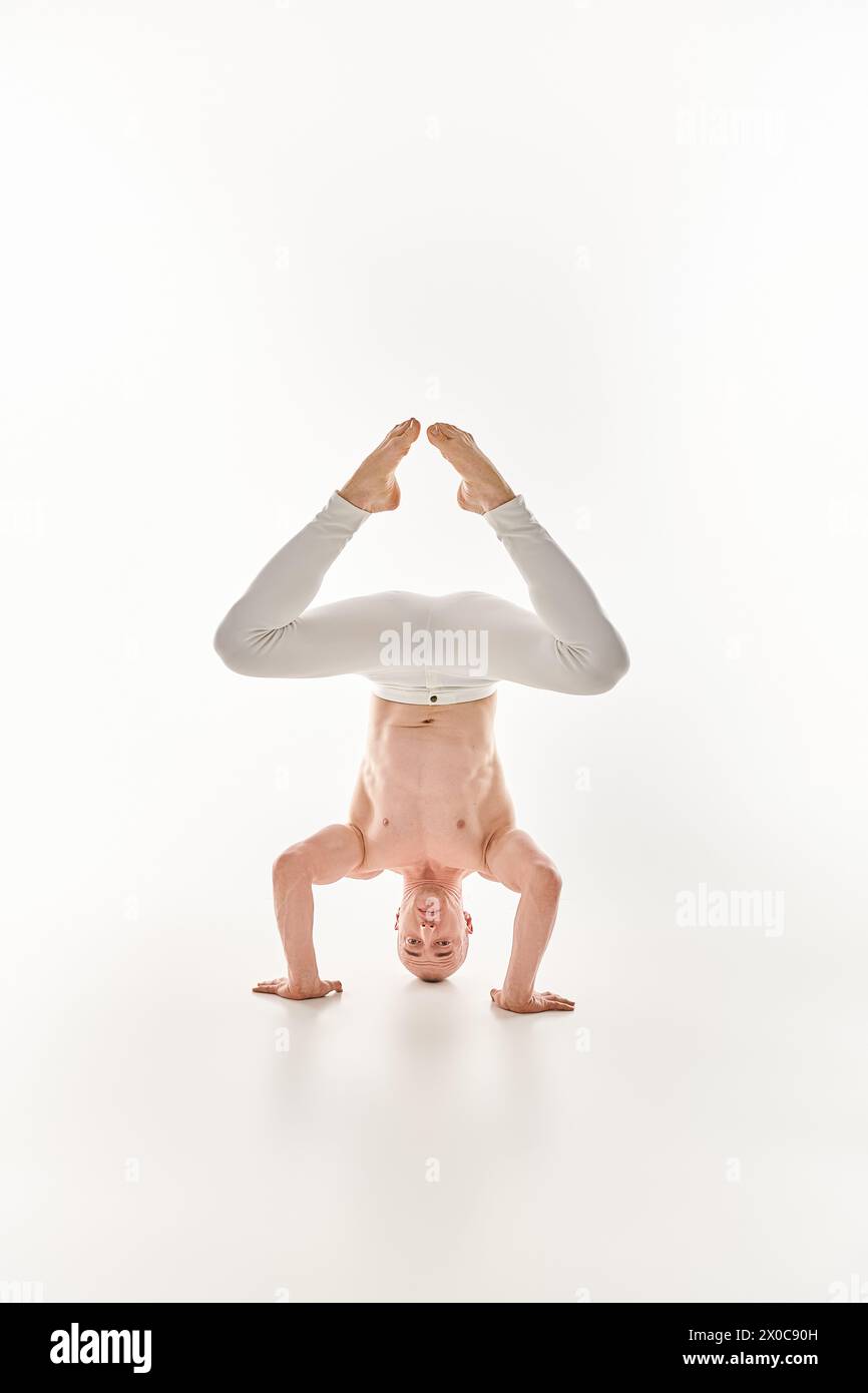 A young man showcases his acrobatic skills by performing a headstand ...