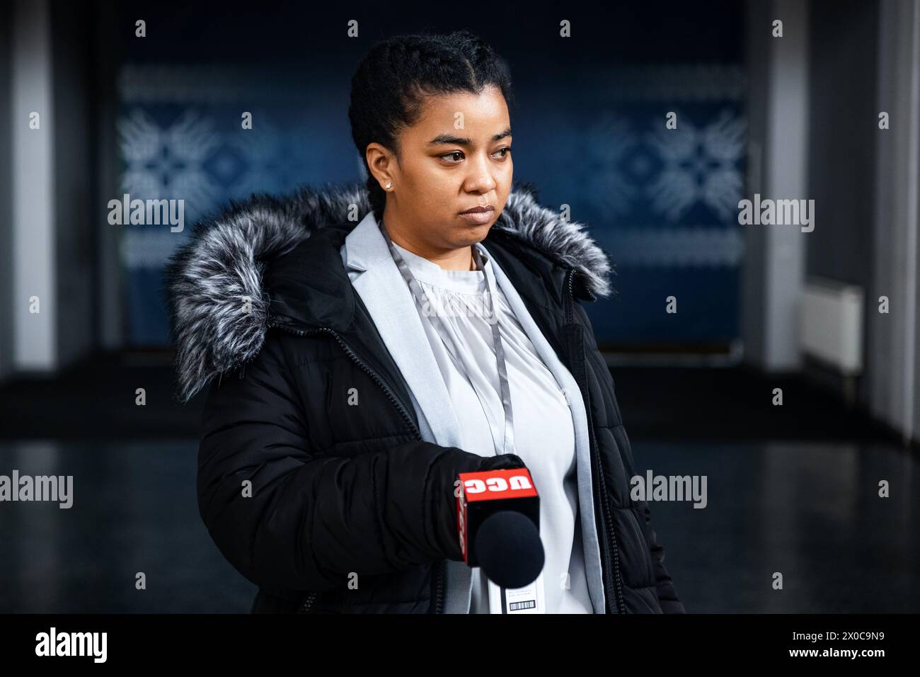 Female journalist with a microphone in her hand observes and prepares ...