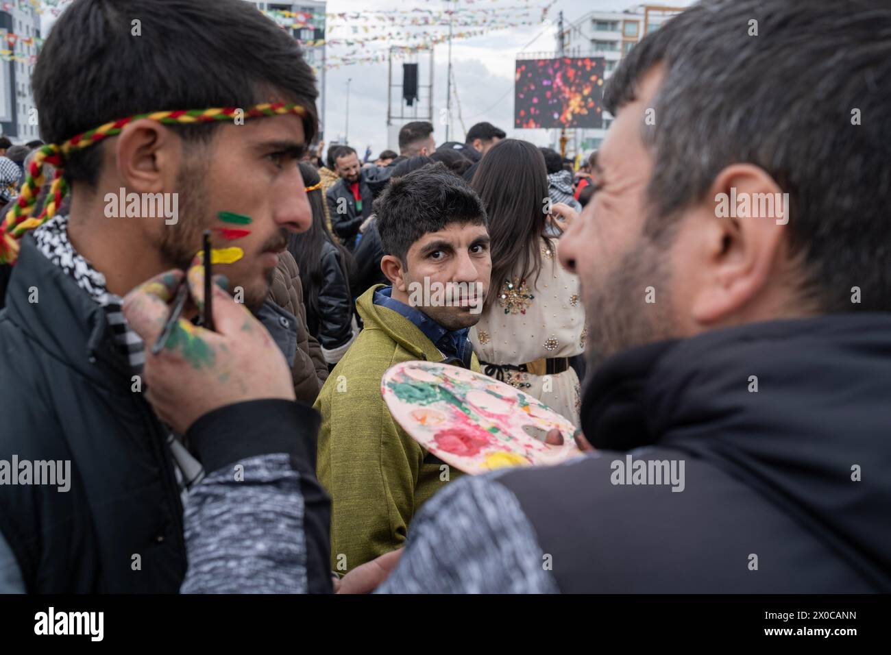 Diyarbakir, Turkey. 21st Mar, 2024. A young man has his cheek painted ...
