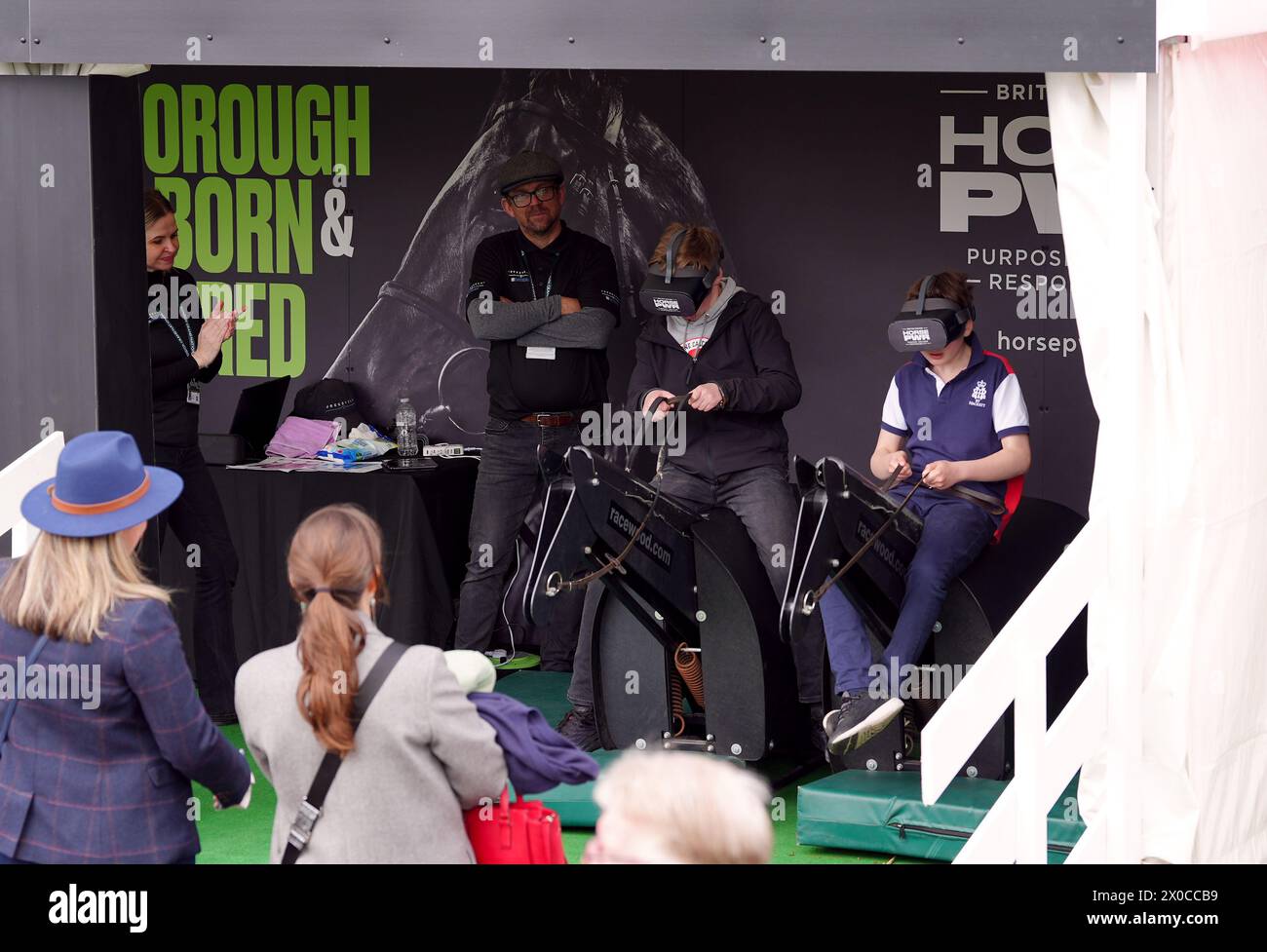 Racegoers take part in a vr horse racing experience on day one of the ...