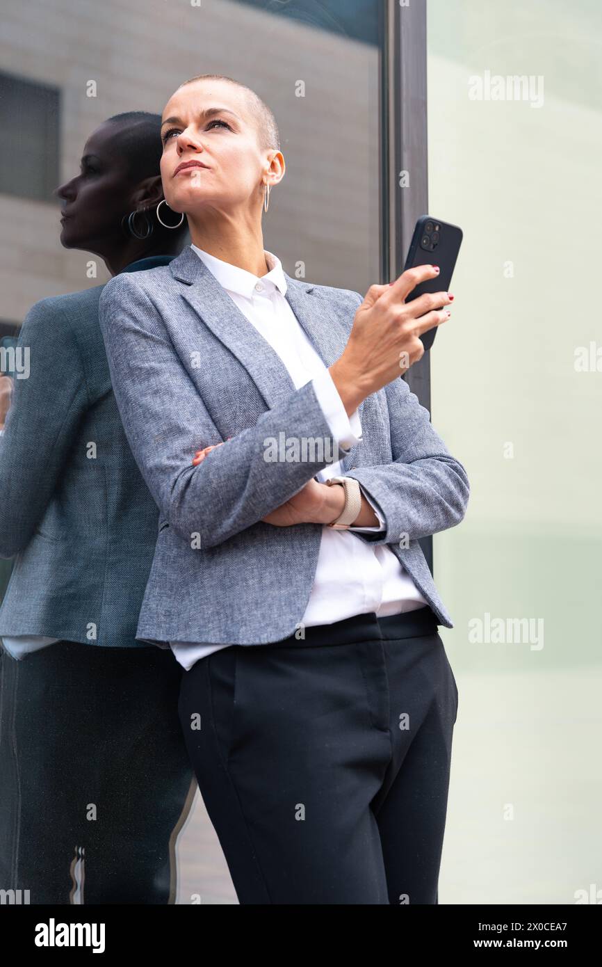 Vertical shot thoughtful Caucasian business woman using an app on her ...
