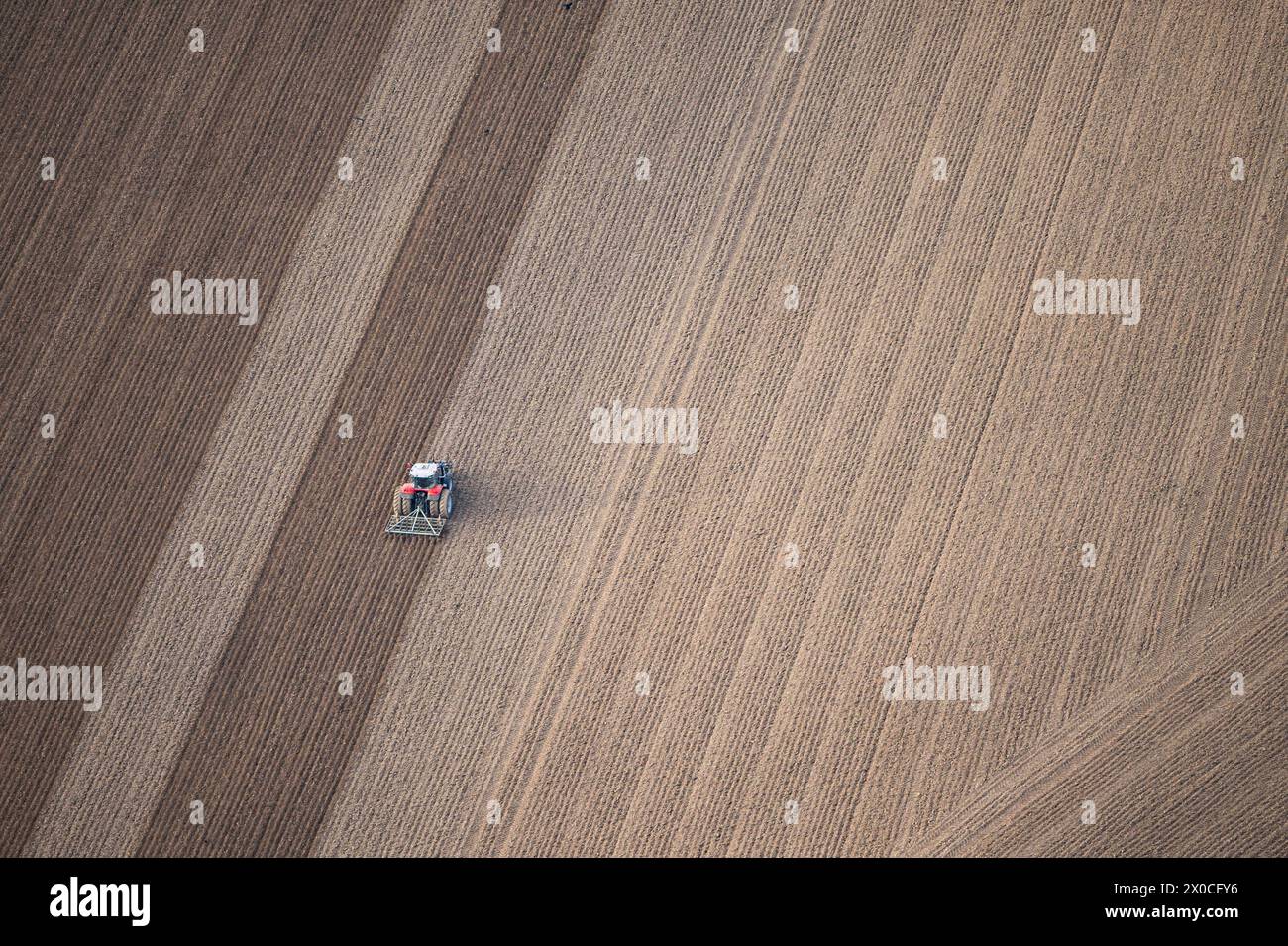 This Pictures shows a tractor and its farmer working in his field on a ...