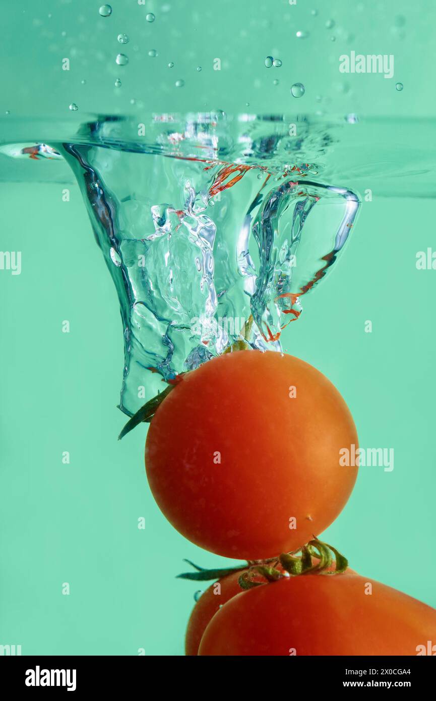 FOOD; red tomatoes falling in a water container Stock Photo - Alamy