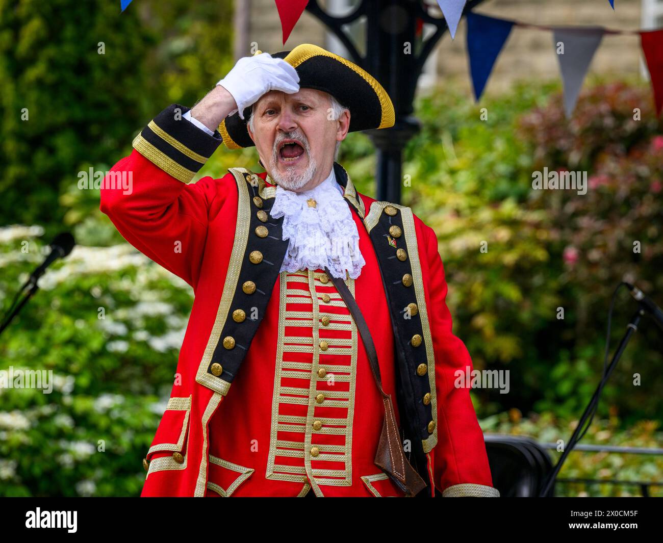 Male town crier (colourful red braided crier's livery) proclaiming ...
