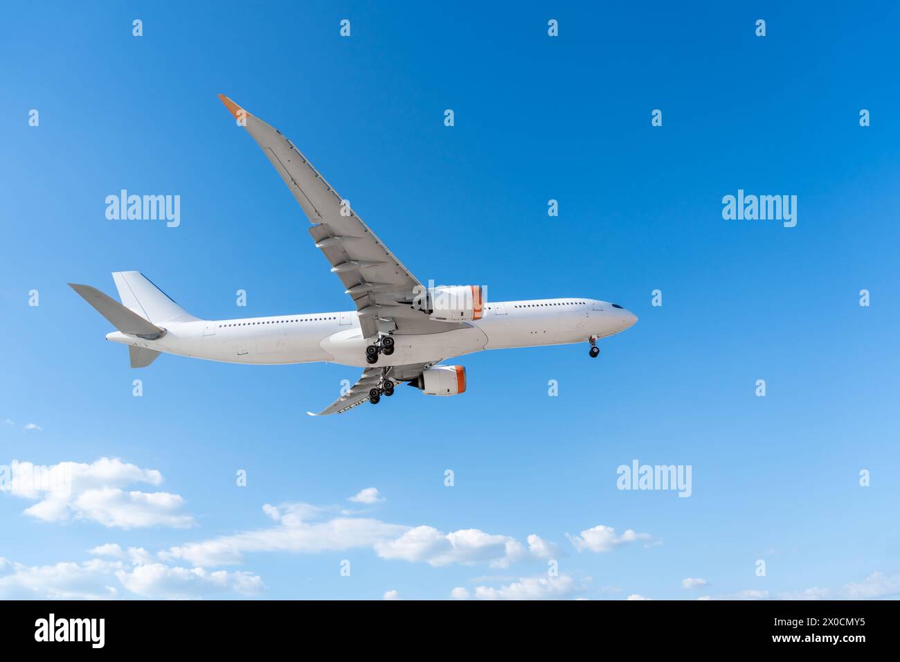 Airplane passenger plane with landing gear extended flying on blue sky ...