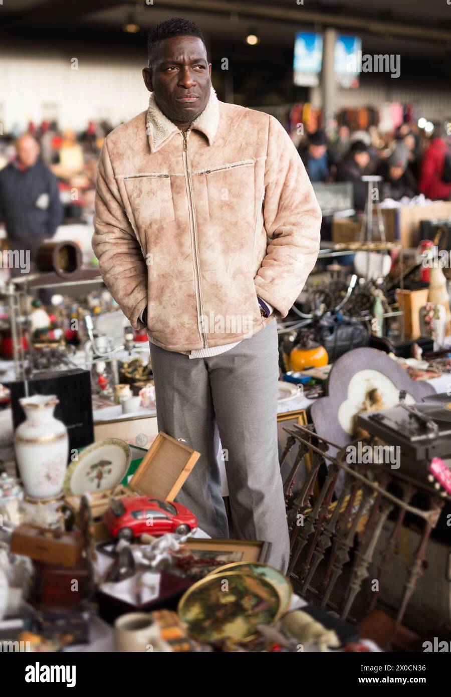 Ordinary afro-american seller in a flea market is waiting for buyers ...