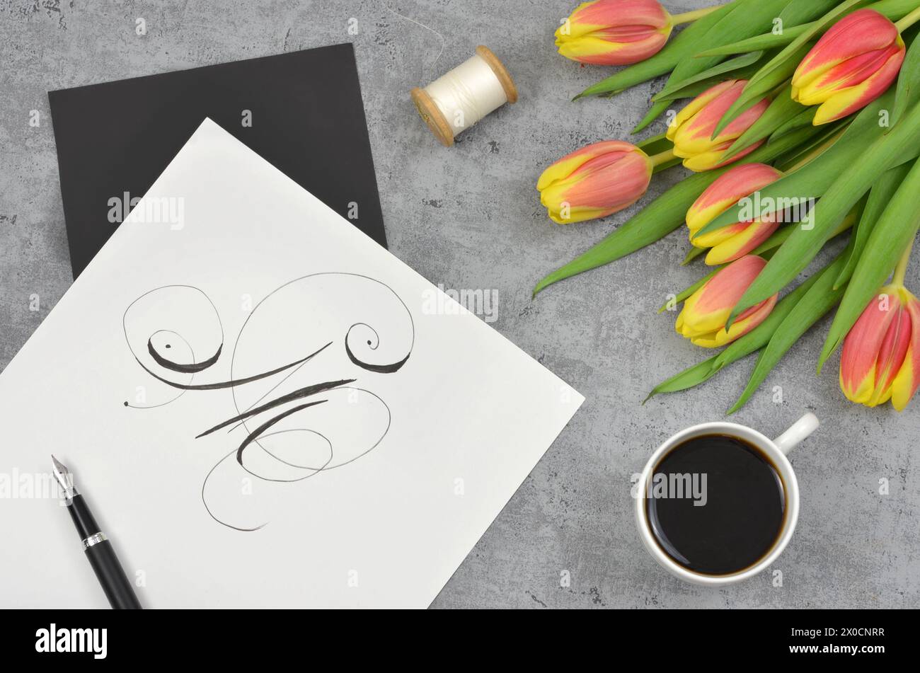 Tulips with sheet of paper with calligraphy letter. Pen, coffee and ...