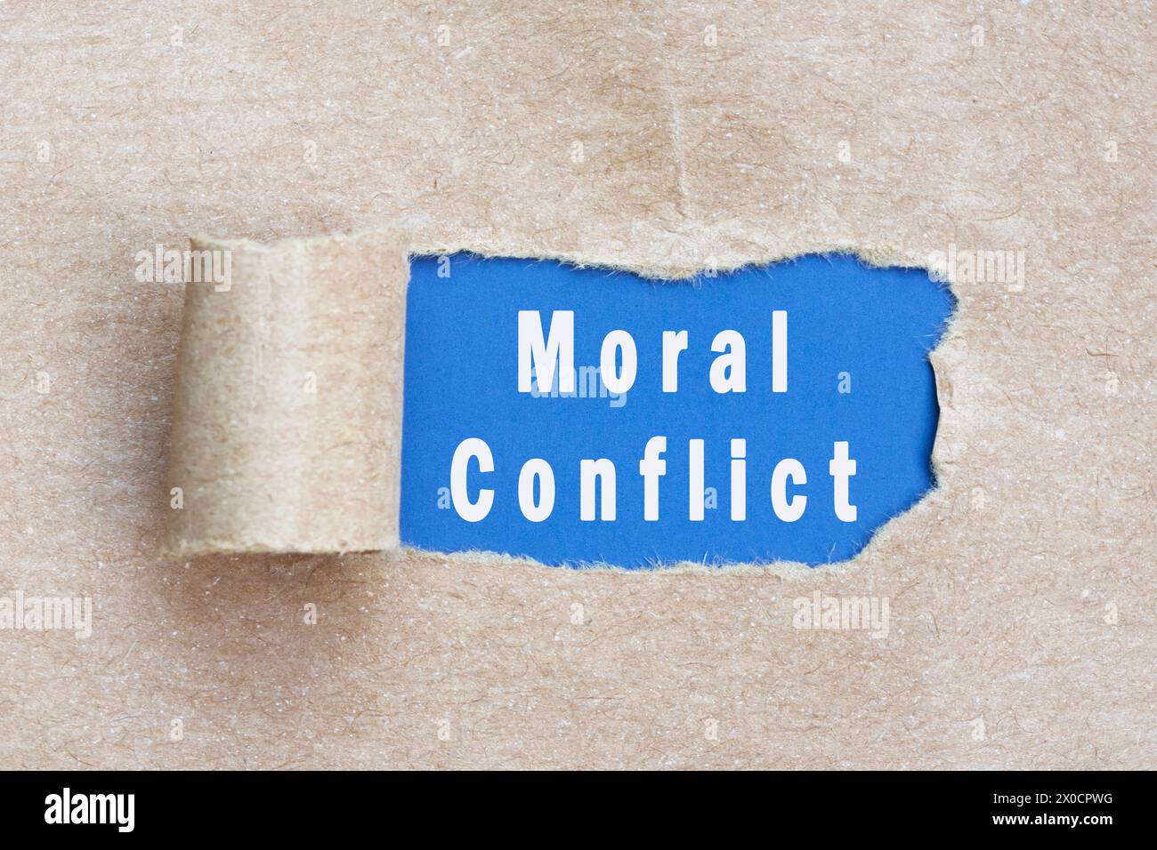 Moral conflict text on brown paper with torn hole Stock Photo - Alamy