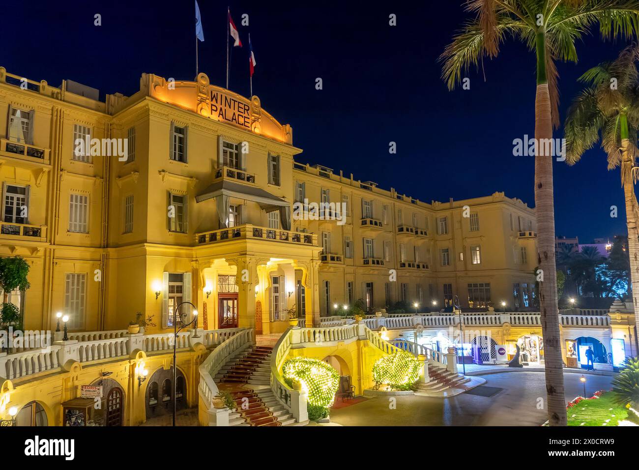 Famous old Winter Palace hotel at night, on the banks of the Nile river ...