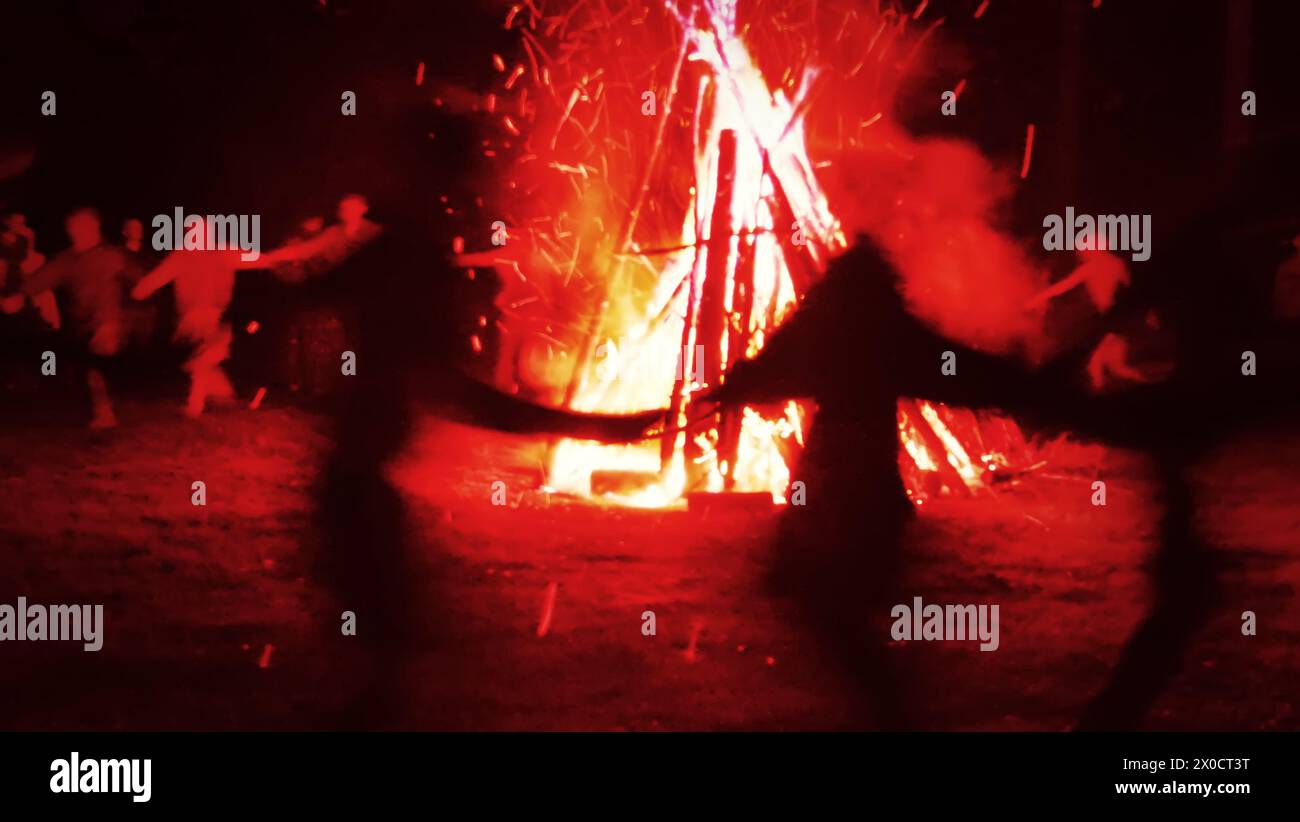 Huge fire at night and young people around. Pagan festival of Walpurgis ...