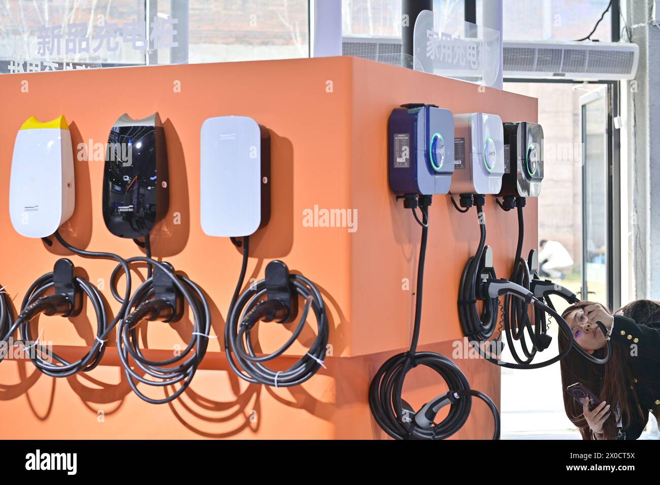 Beijing, China. 11th Apr, 2024. A visitor looks at the charging station ...