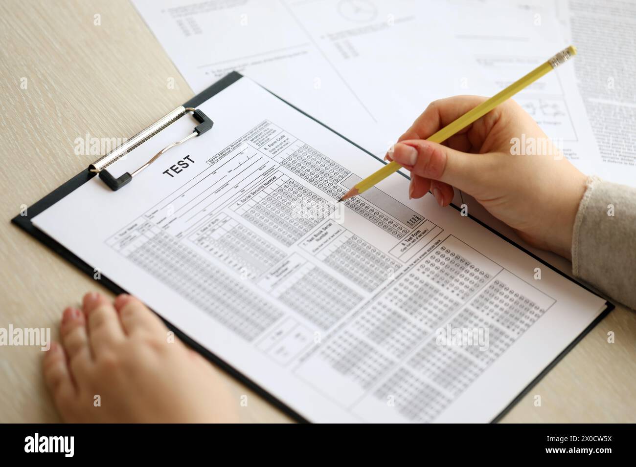Female student hands testing in exercise and taking fill in exam paper ...
