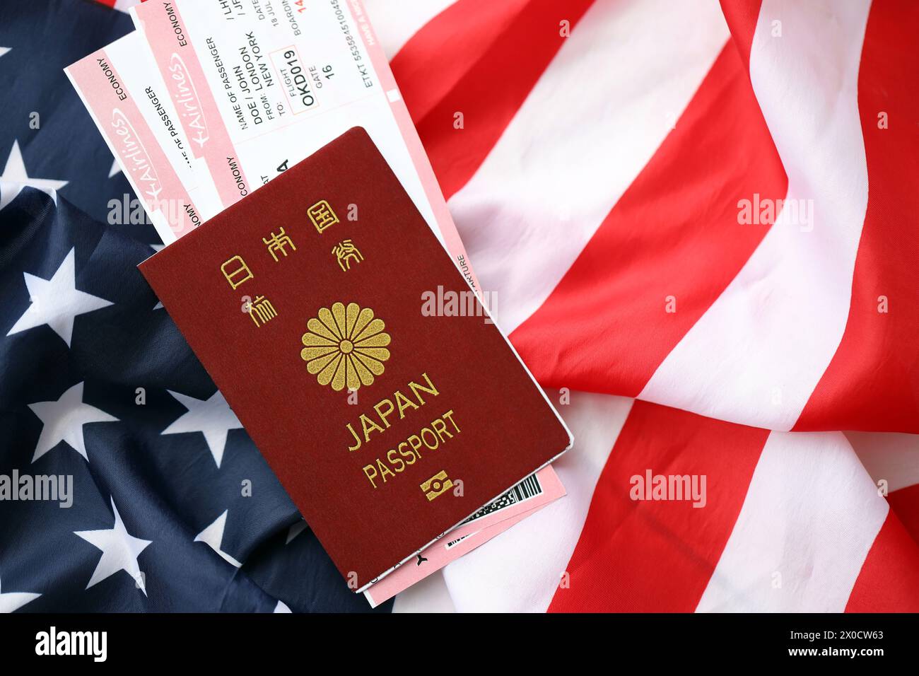 Japan passport with airline tickets on American US flag close up ...