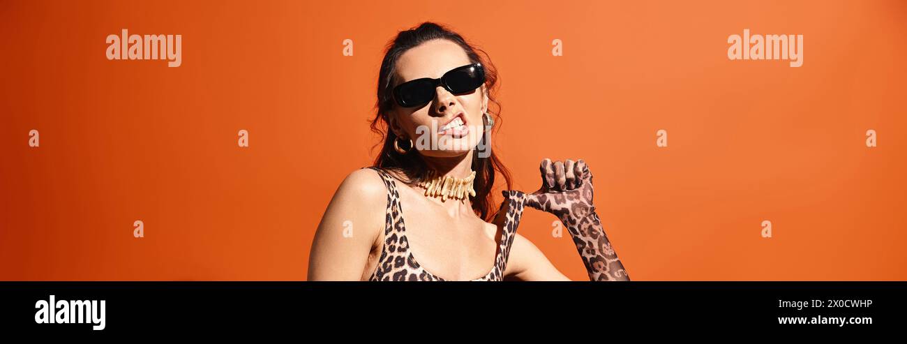 A stylish woman in a leopard print dress poses with a leopard print in ...