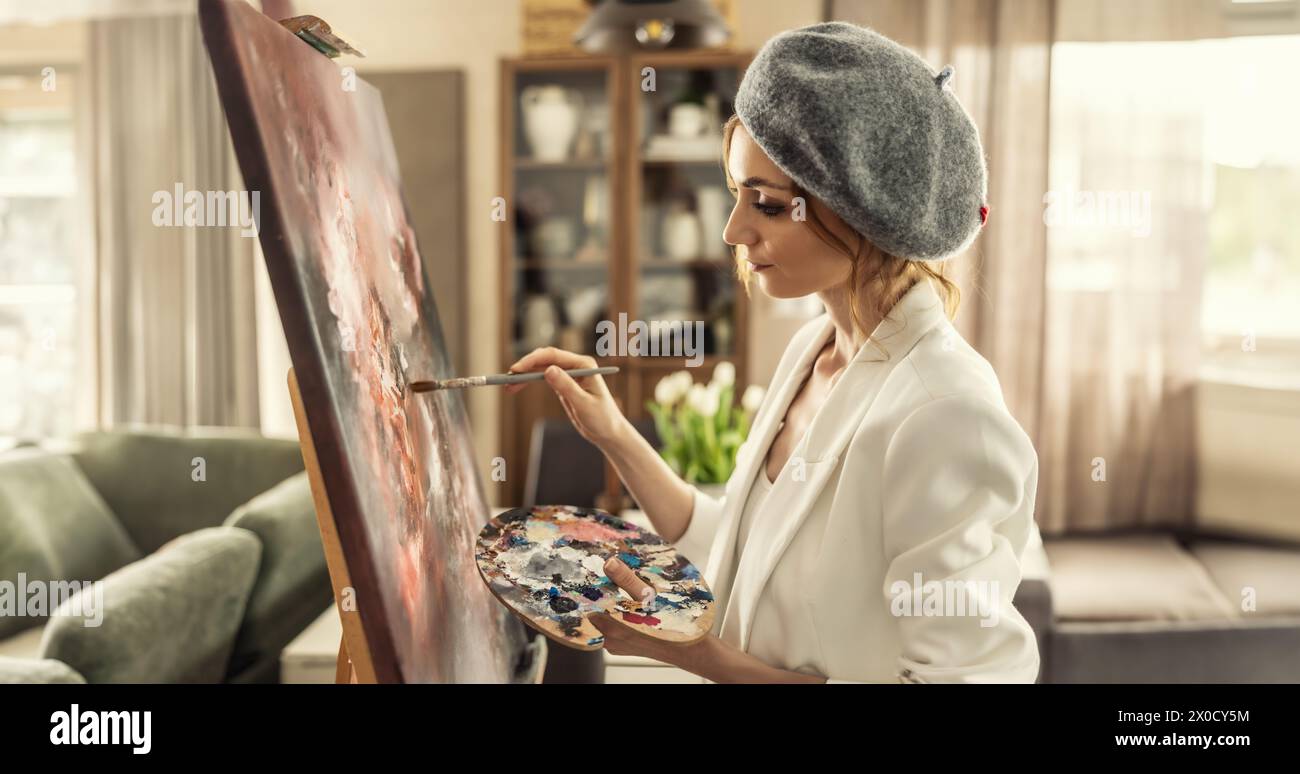 Beautiful female painter enjoying while painting in home art studio ...