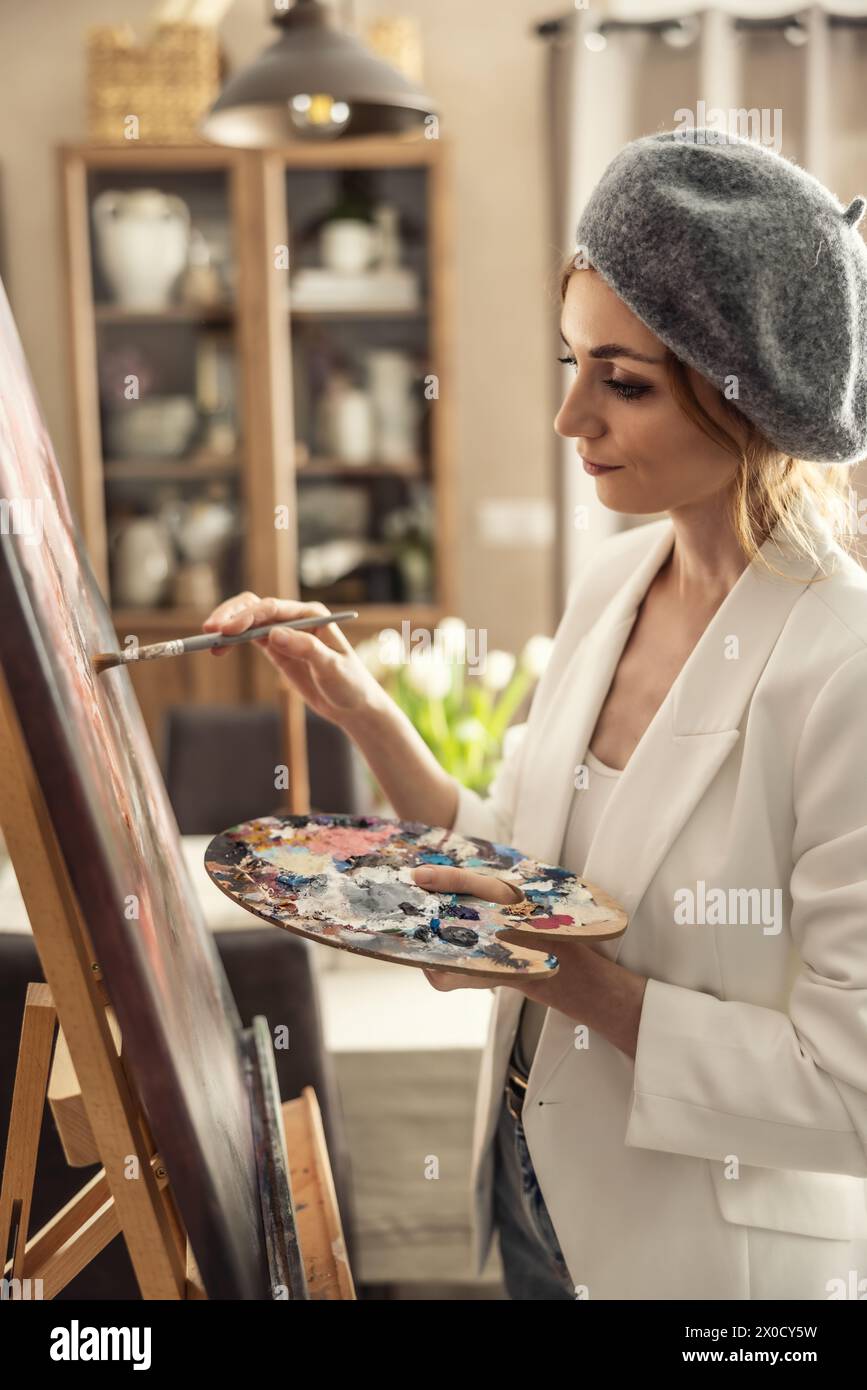 Beautiful female painter enjoying while painting in home art studio ...