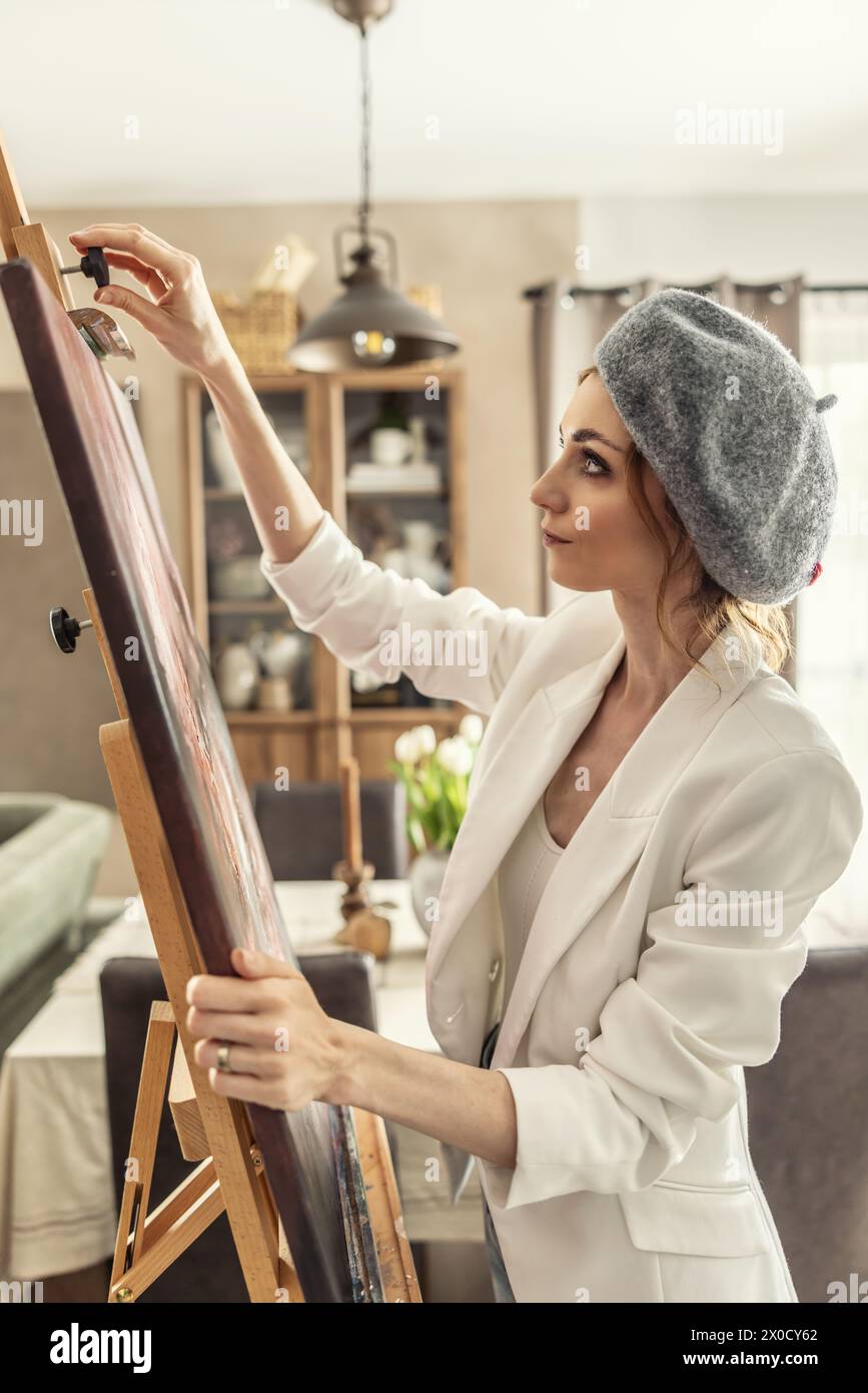 Beautiful female painter enjoying while painting in home art studio ...