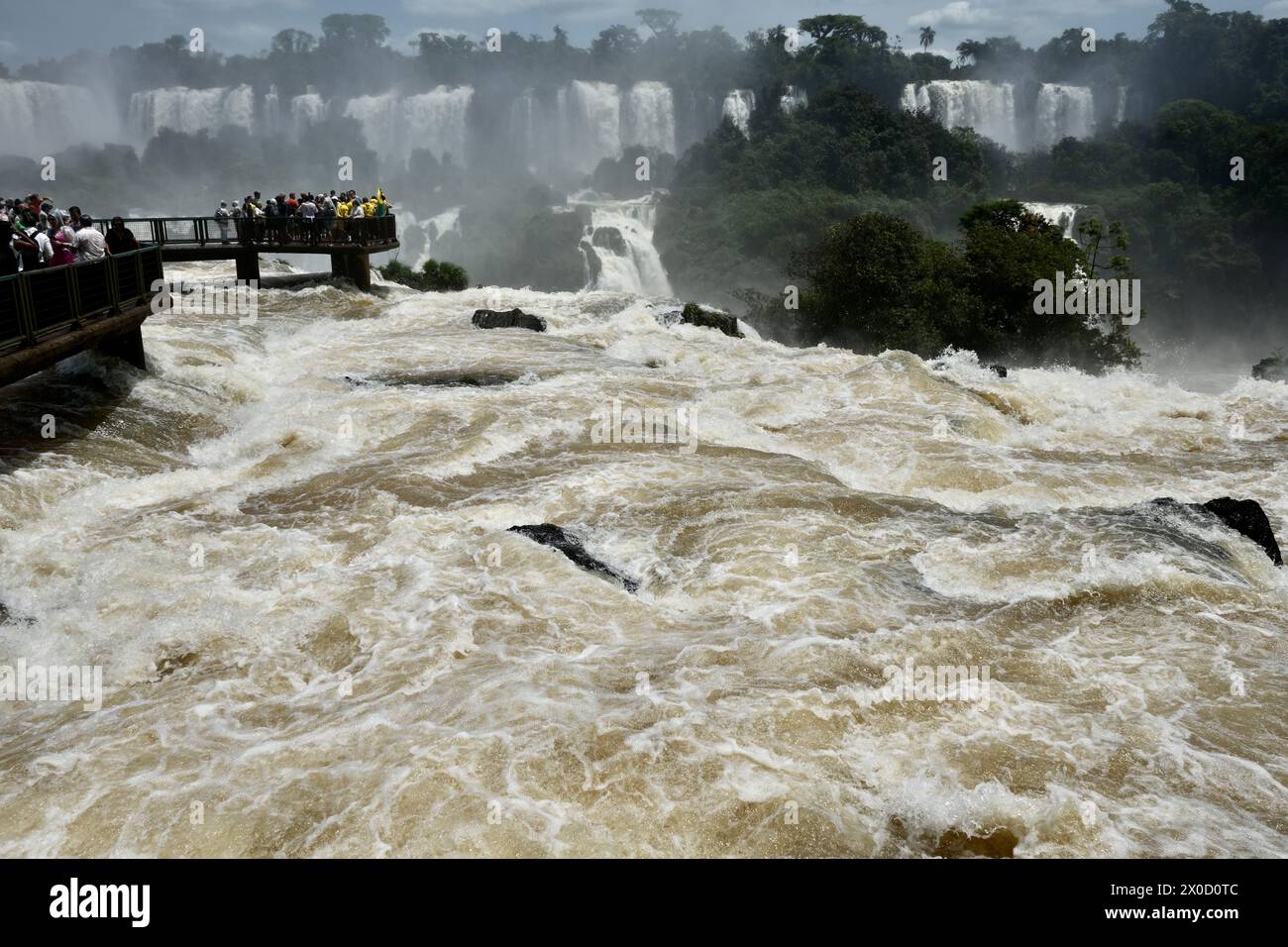 Visitors looking out over the powerful Iguazu Waterfalls at their ...