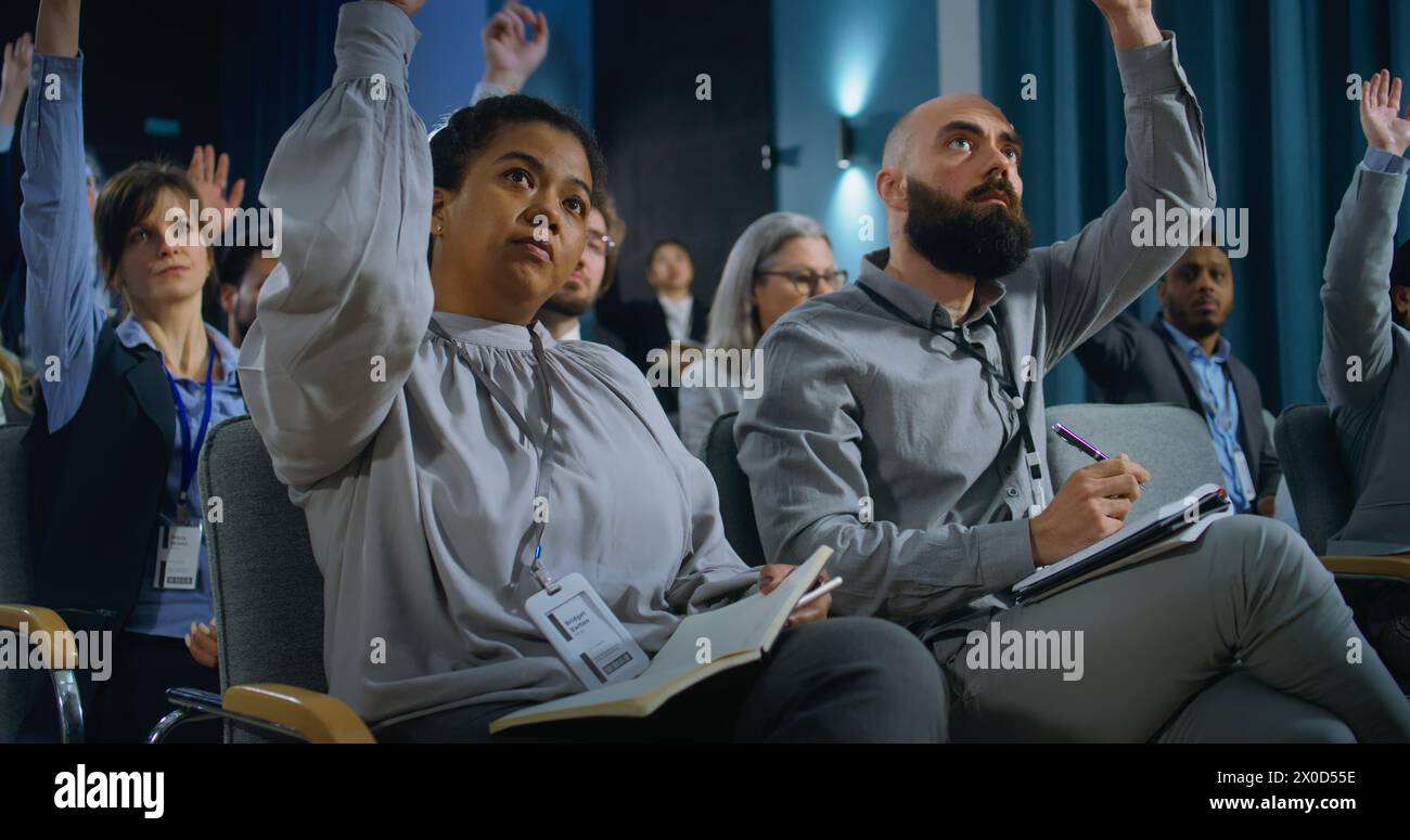 Diverse journalists raise hands to ask questions at press campaign in ...