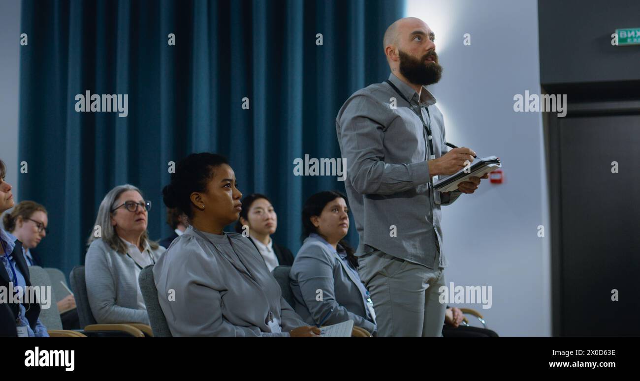 Caucasian male media representative stands up and asks questions during ...