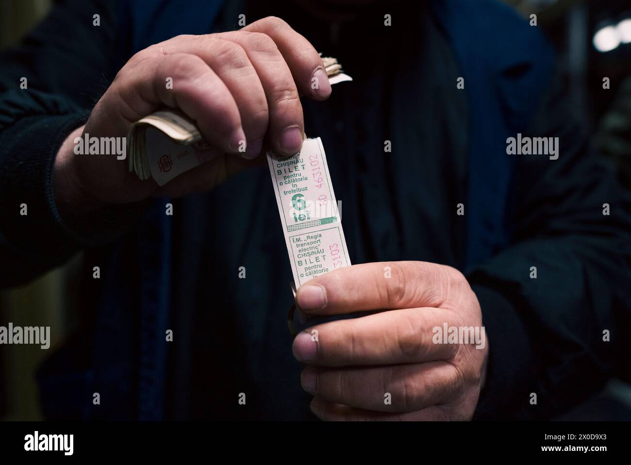 In a Trolleybus, a ticket seller with a packet of tickets in one hand ...