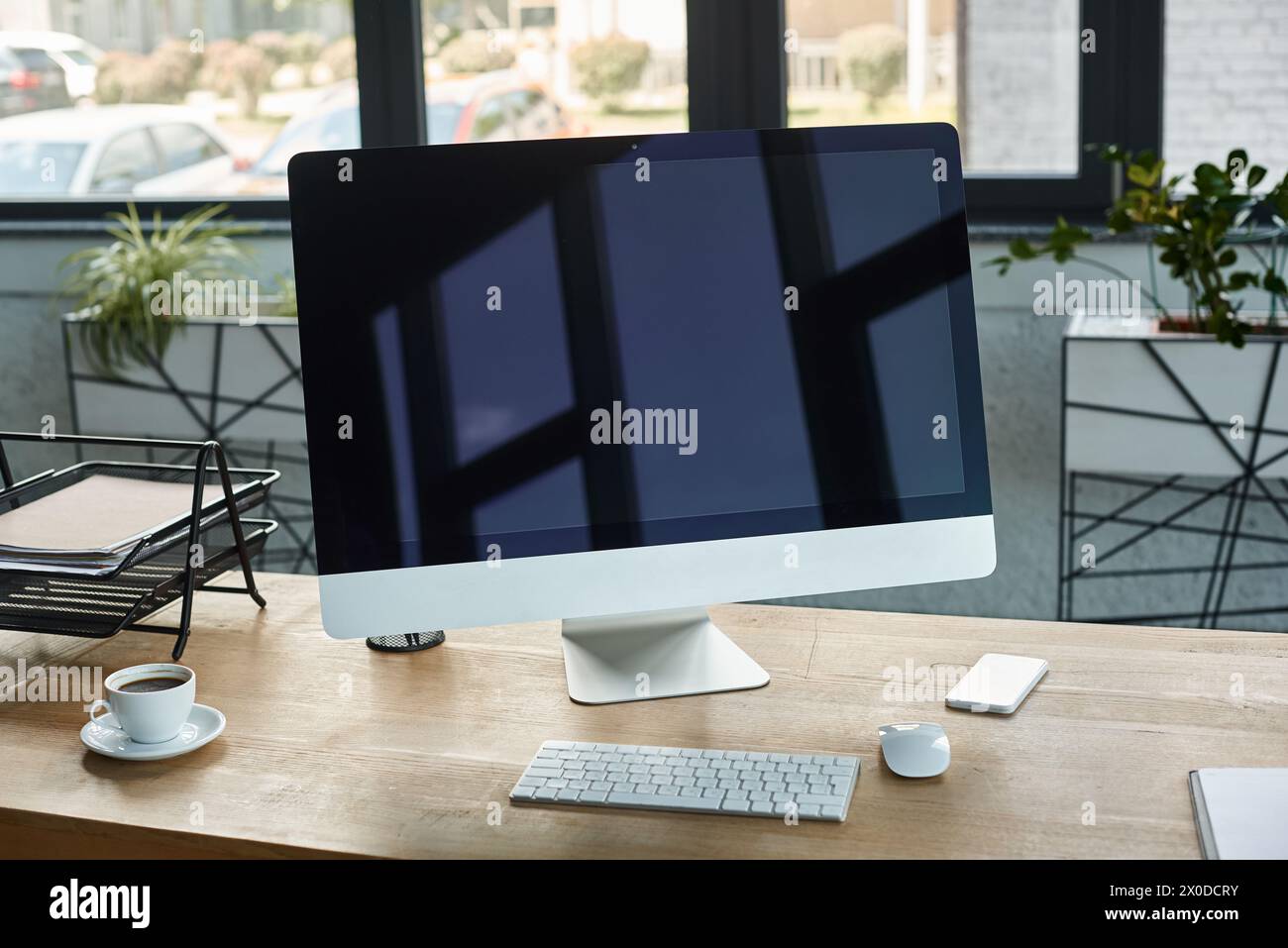 A sleek desktop computer rests atop a wooden desk in a modern office ...