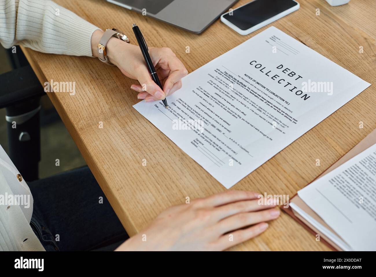 A businesswoman seated at a desk, focused on jotting down notes with a ...