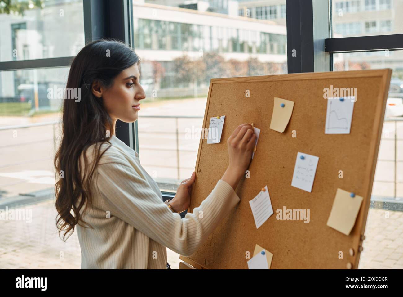 A dynamic female entrepreneur stands confidently in front of a board ...