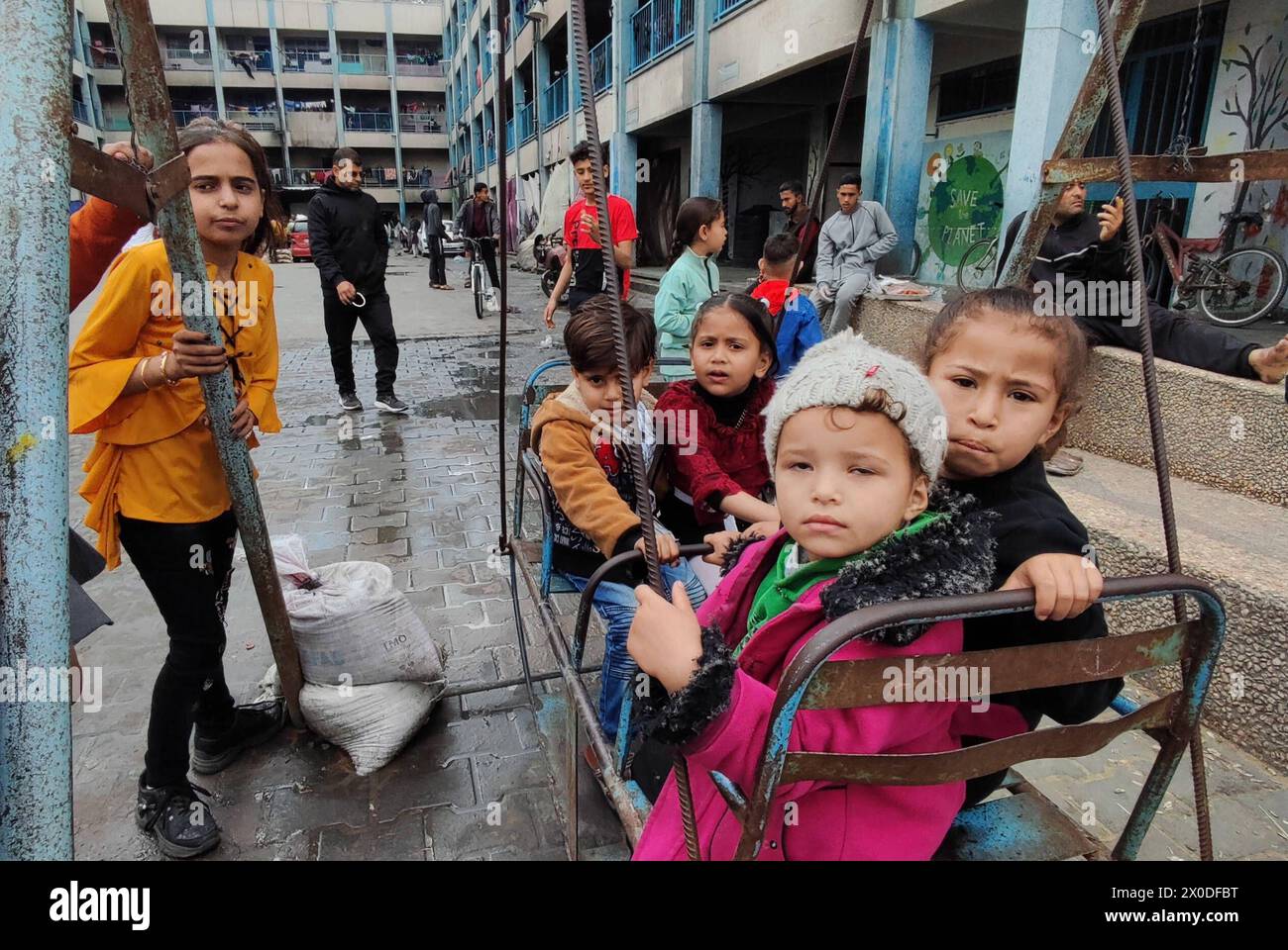 Palestinian children spend time playing on swings Inside a shelter ...