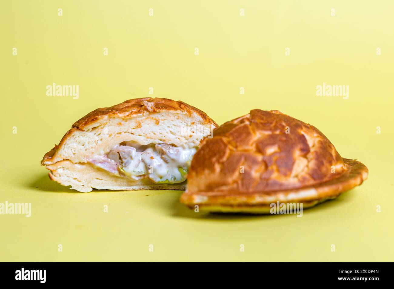 juicy burger cut with delicious filling on a yellow background Stock ...