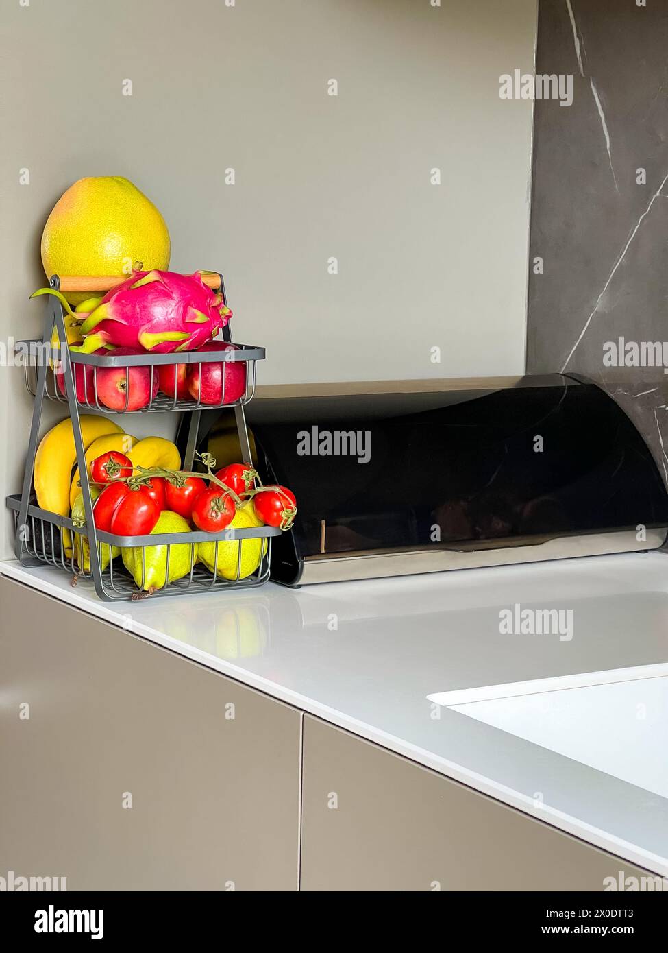 Two-story exotic fruit metal basket and black bread bin in the kitchen ...
