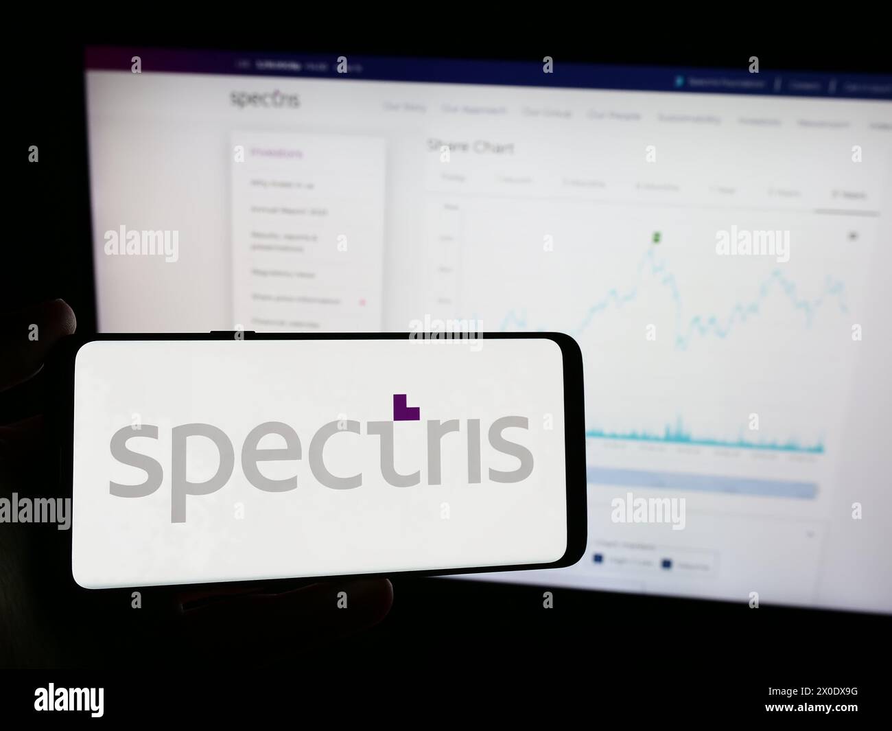 Person holding mobile phone with logo of British precision ...