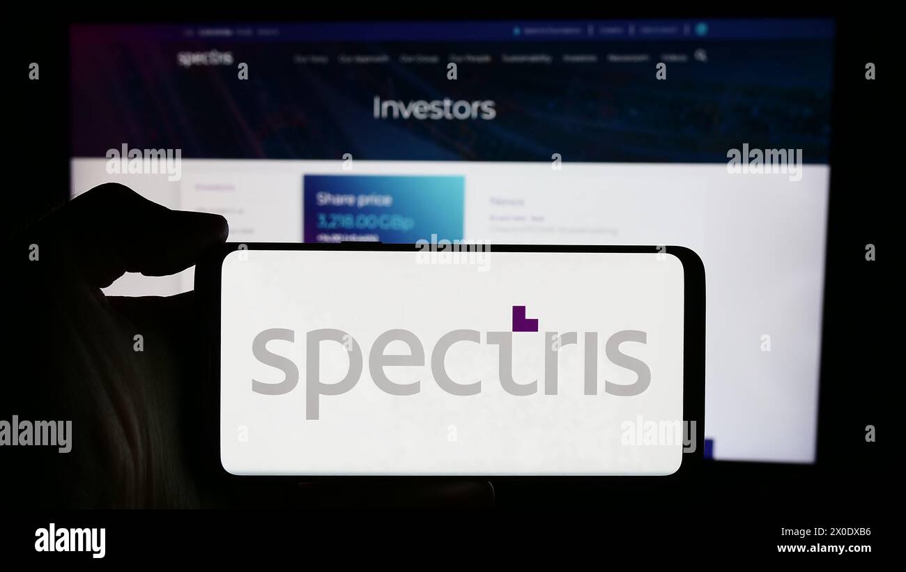 Person holding smartphone with logo of British precision ...