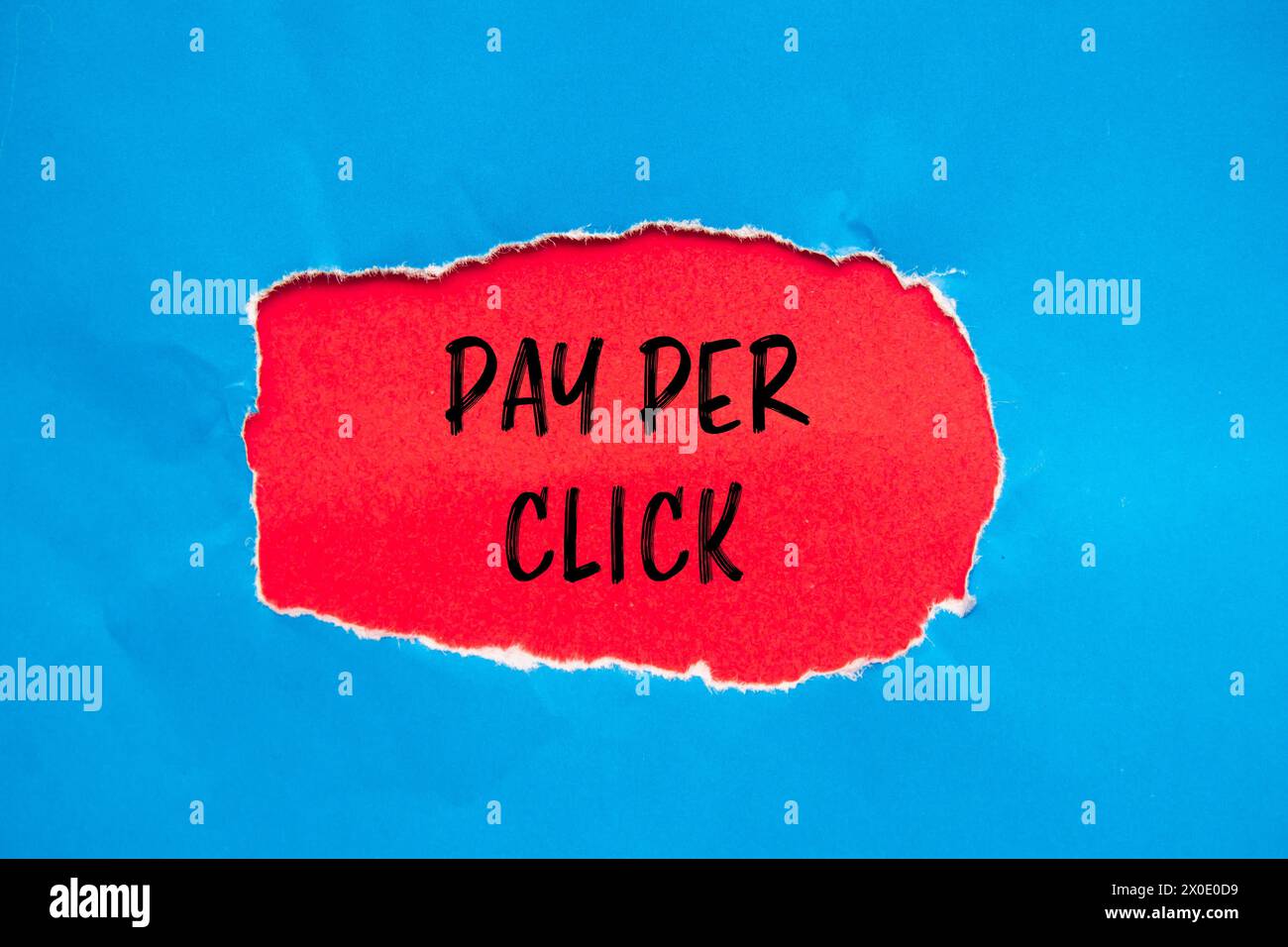 Pay per click words written on ripped blue paper with red background ...