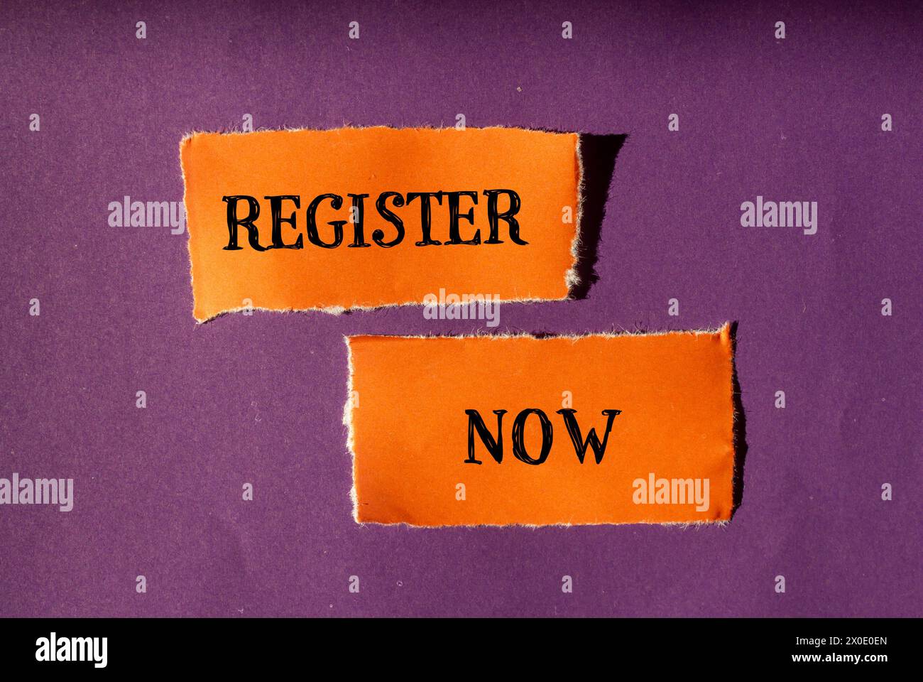 Register now words written on ripped orange paper pieces with purple ...
