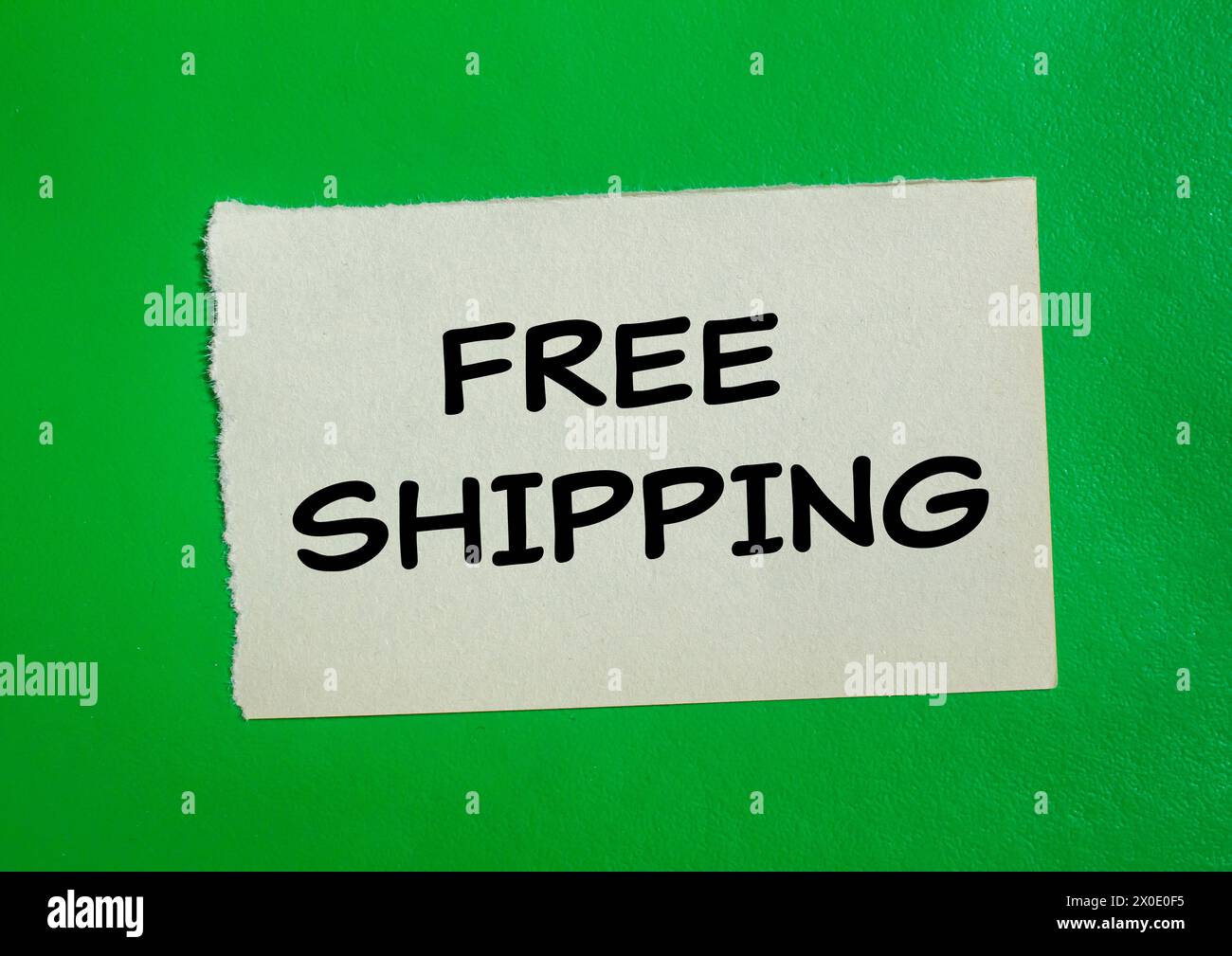 Free shipping words written on ripped paper with green background ...